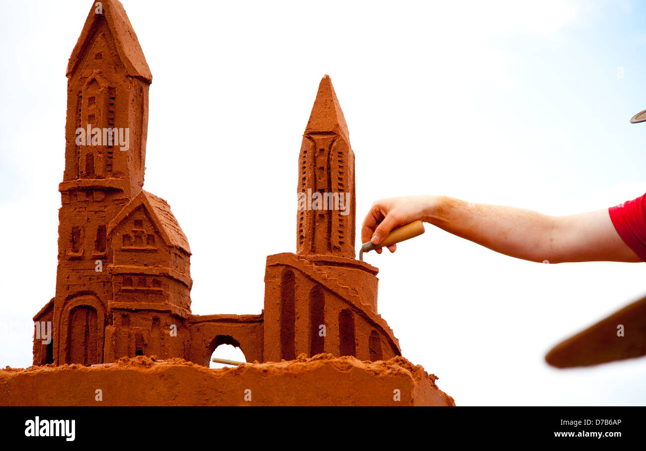 Sand artists Sand In Your Eye creating a sculpture of a castle on Rhyl ...