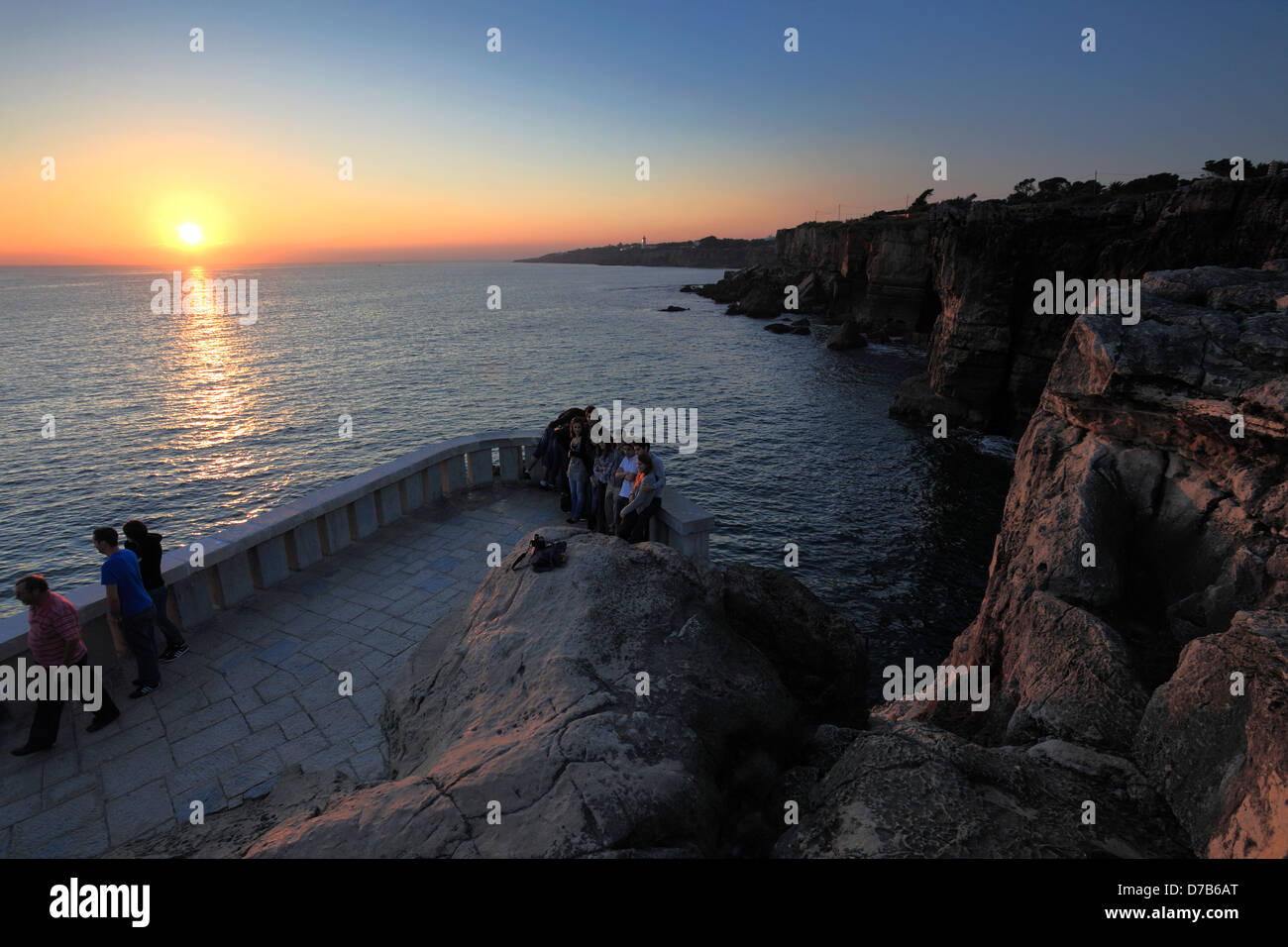 People watching the sunset over the Atlantic Ocean at Boca do Inferno ...