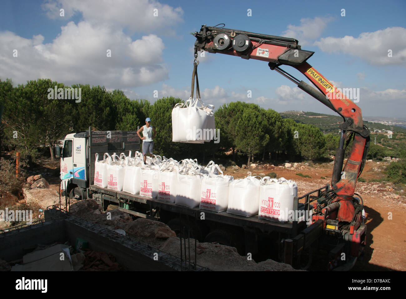 Crane lifting sacks with construction materials Stock Photo - Alamy