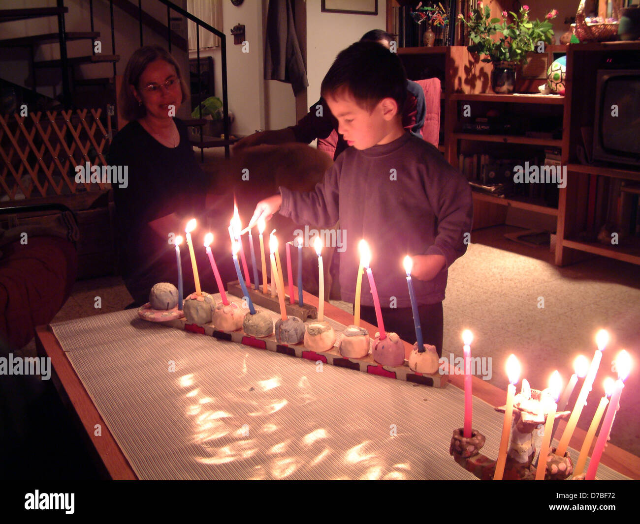 child lighting hanukkah candles (Hanukkah candlestick Stock Photo - Alamy