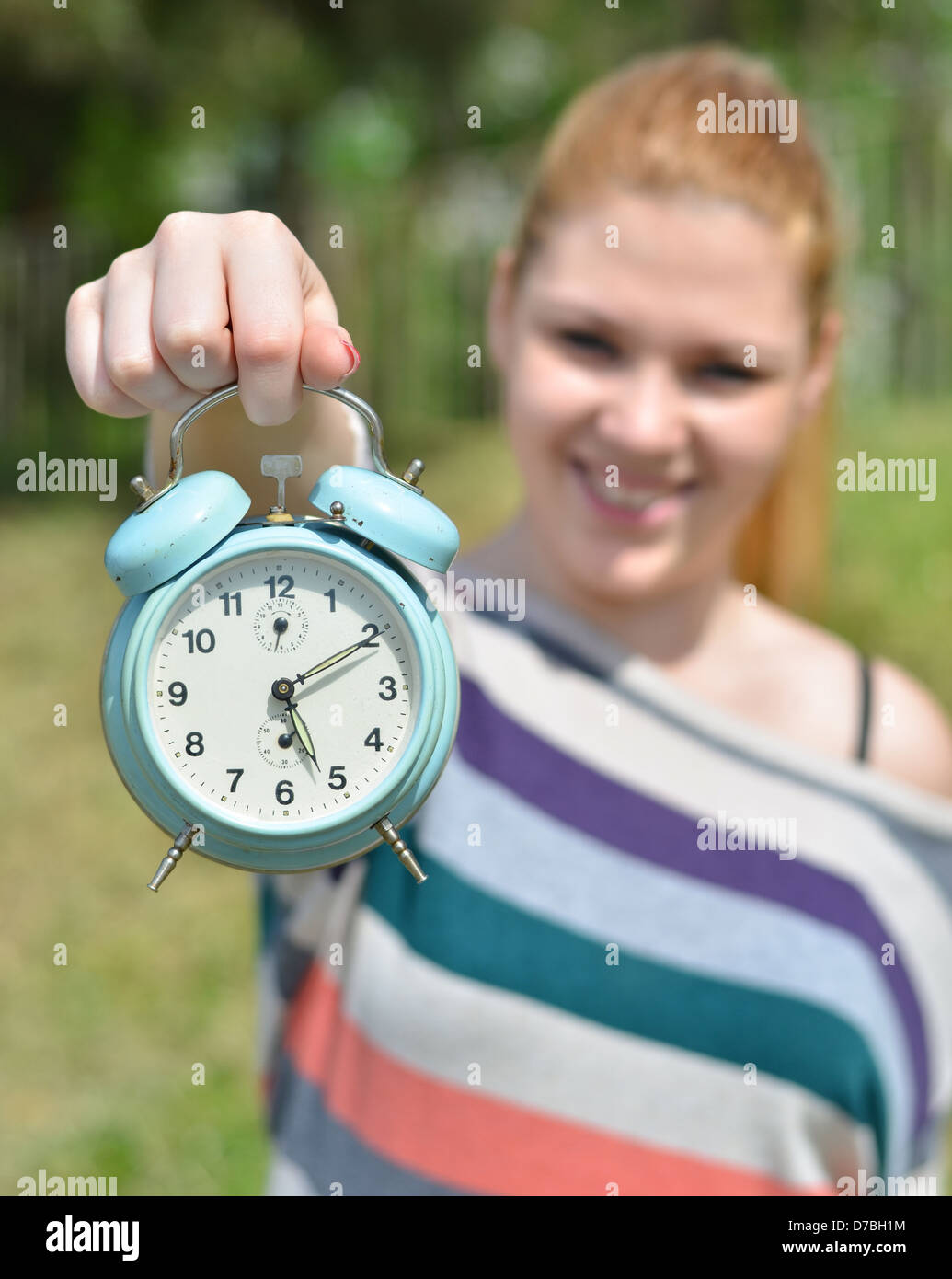 Teenage girl holding vintage clock outdoors with focus on clock Stock ...