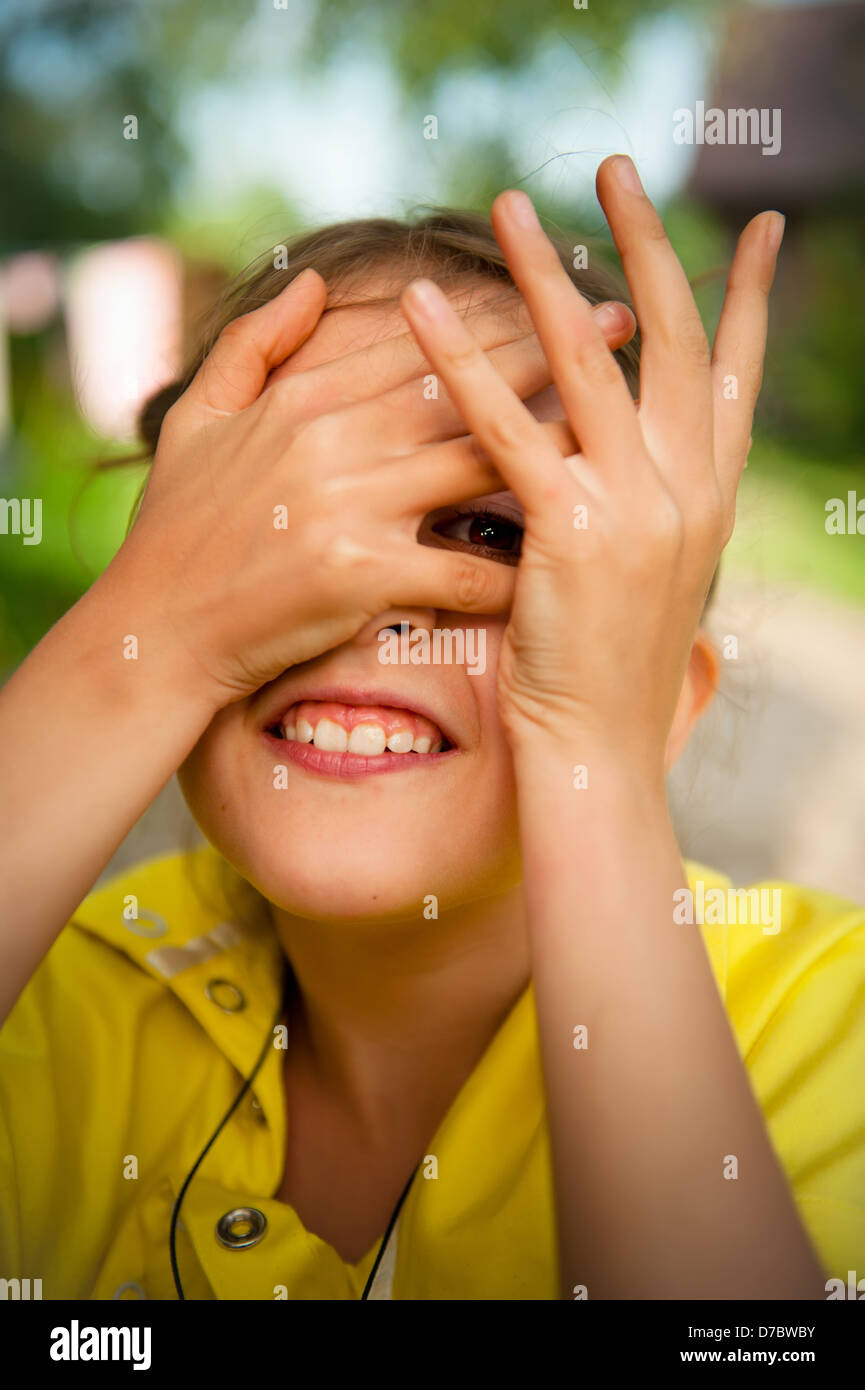 hiding face behind fingers Stock Photo - Alamy