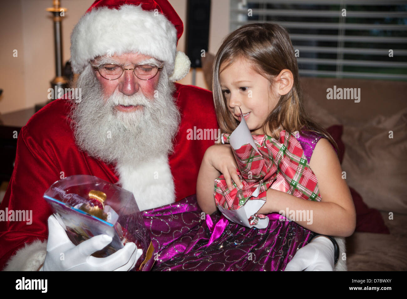 Santa Claus giving little girl a present Stock Photo - Alamy