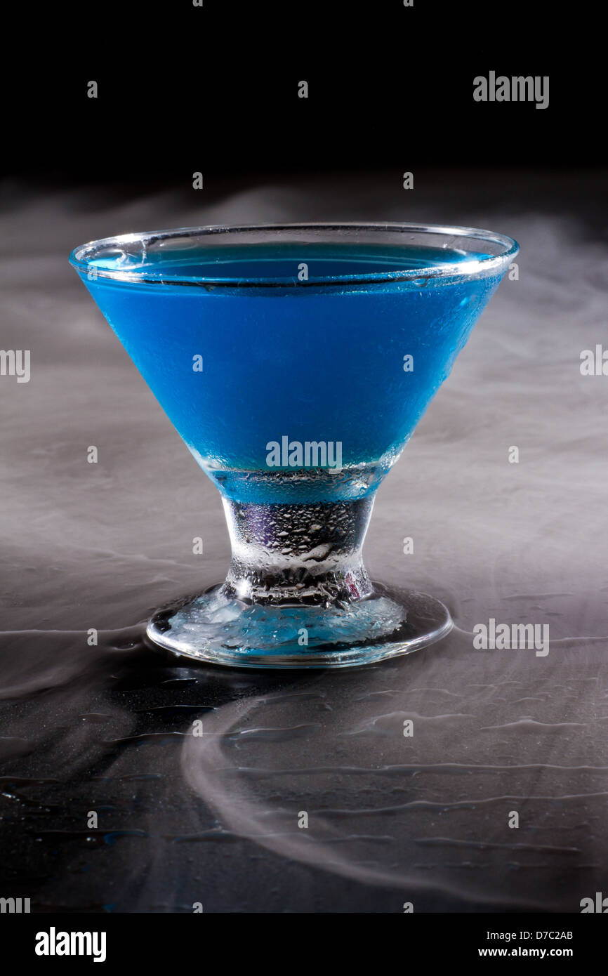 small bright blue cocktail on a dark foggy dramatic bar Stock Photo - Alamy