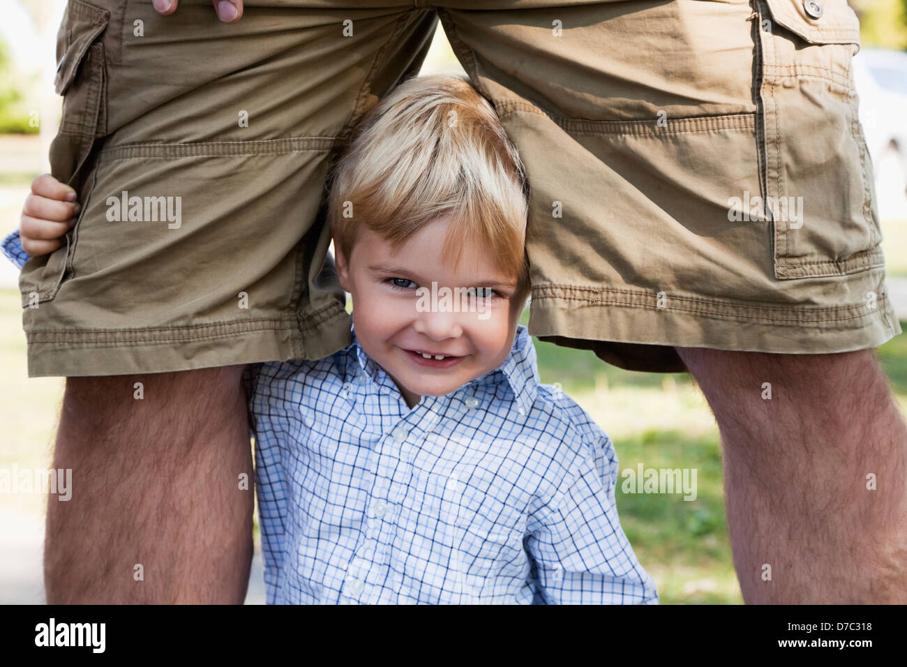 Young Boy Smiling And Hugging His Dad's Legs;Ontario Canada Stock Photo ...