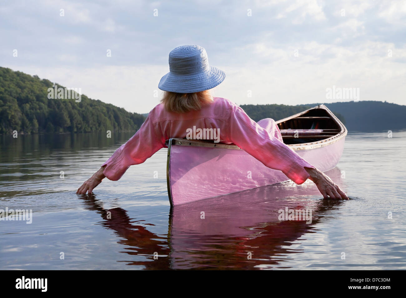 Senior Woman Dressed In Pink And Trailing Her Hands In The Water From ...