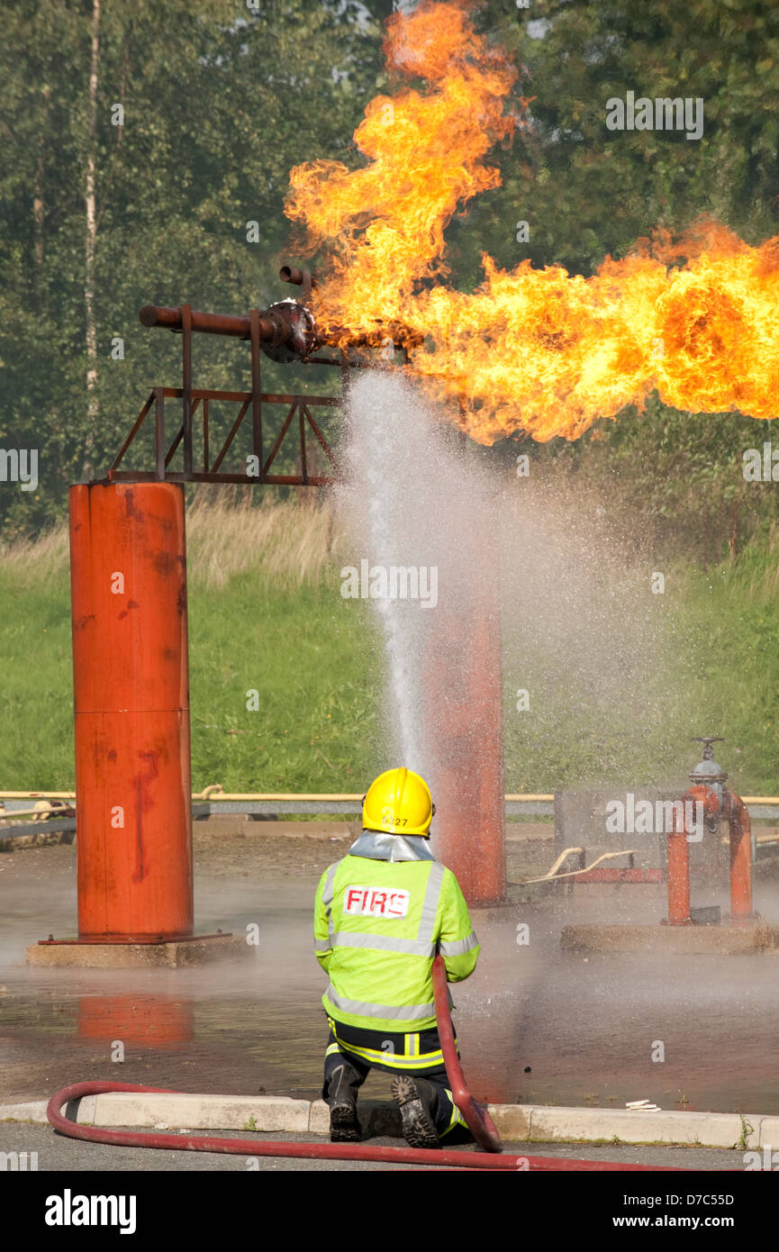 Fireman Firefighter hose water gas pipe fire Stock Photo - Alamy