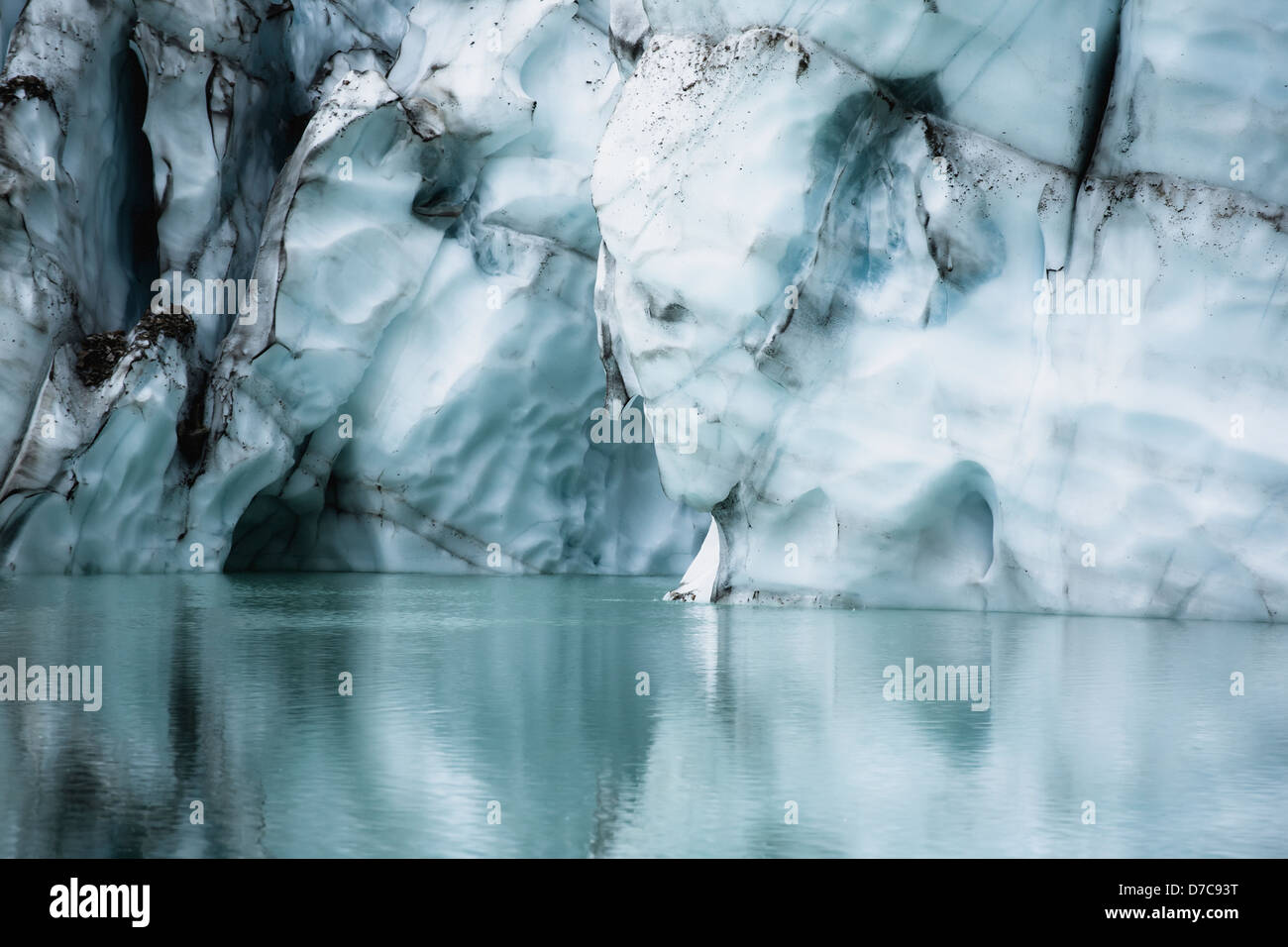 A melting glacier cliff reflected in a small glacial lake jasper ...