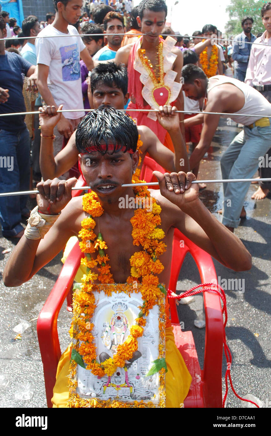 Hindu devotees of Devi Maha Mariamman get their cheeks pierced by a rod ...