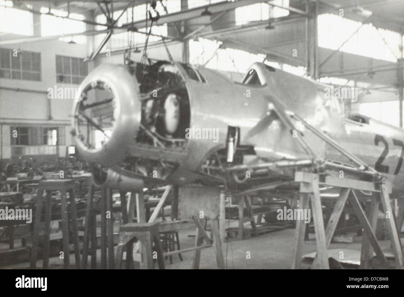 This photograph shows workers assembling and constructing an aircraft ...