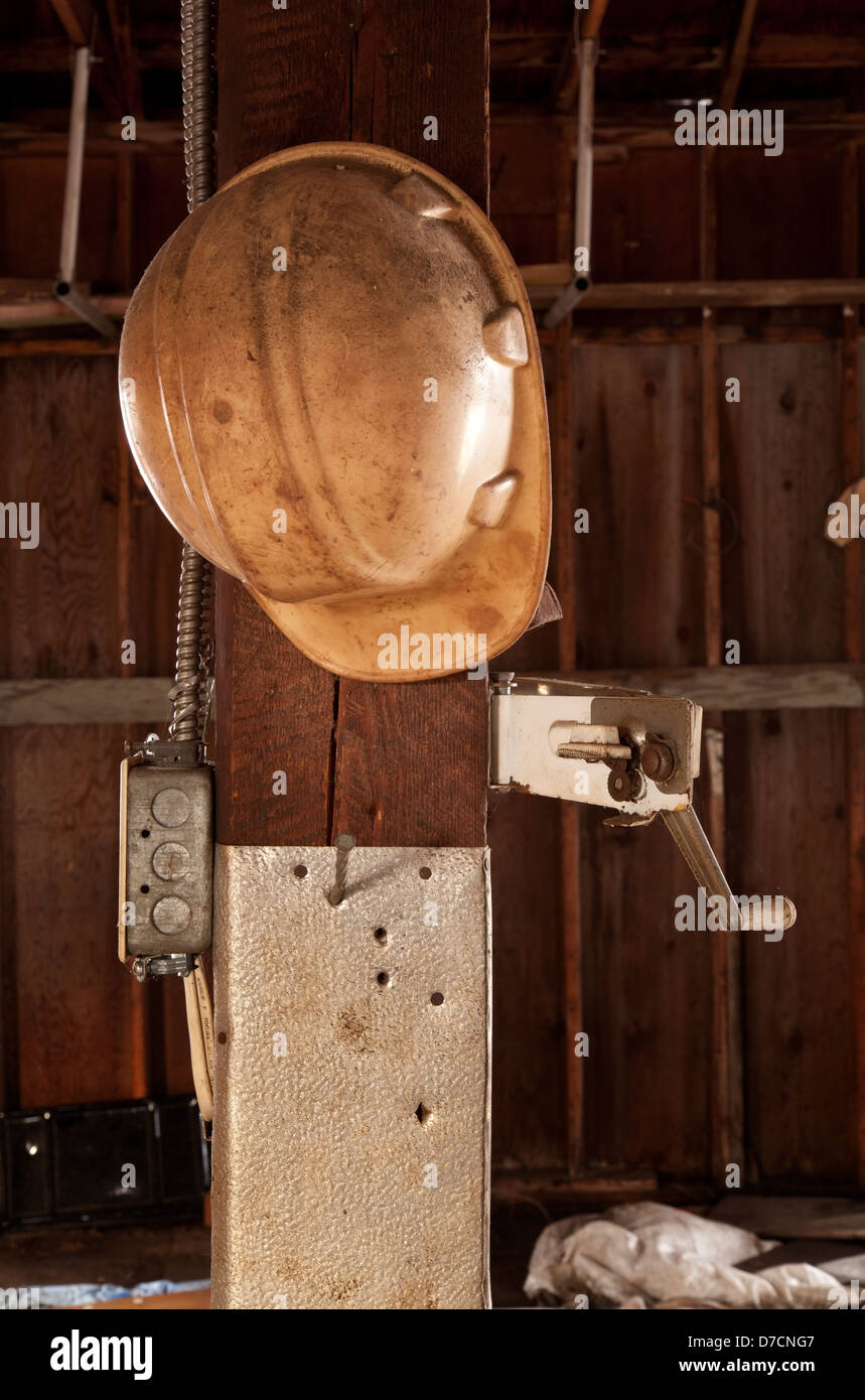 A construction helmet hanging in a dusty shed Stock Photo - Alamy