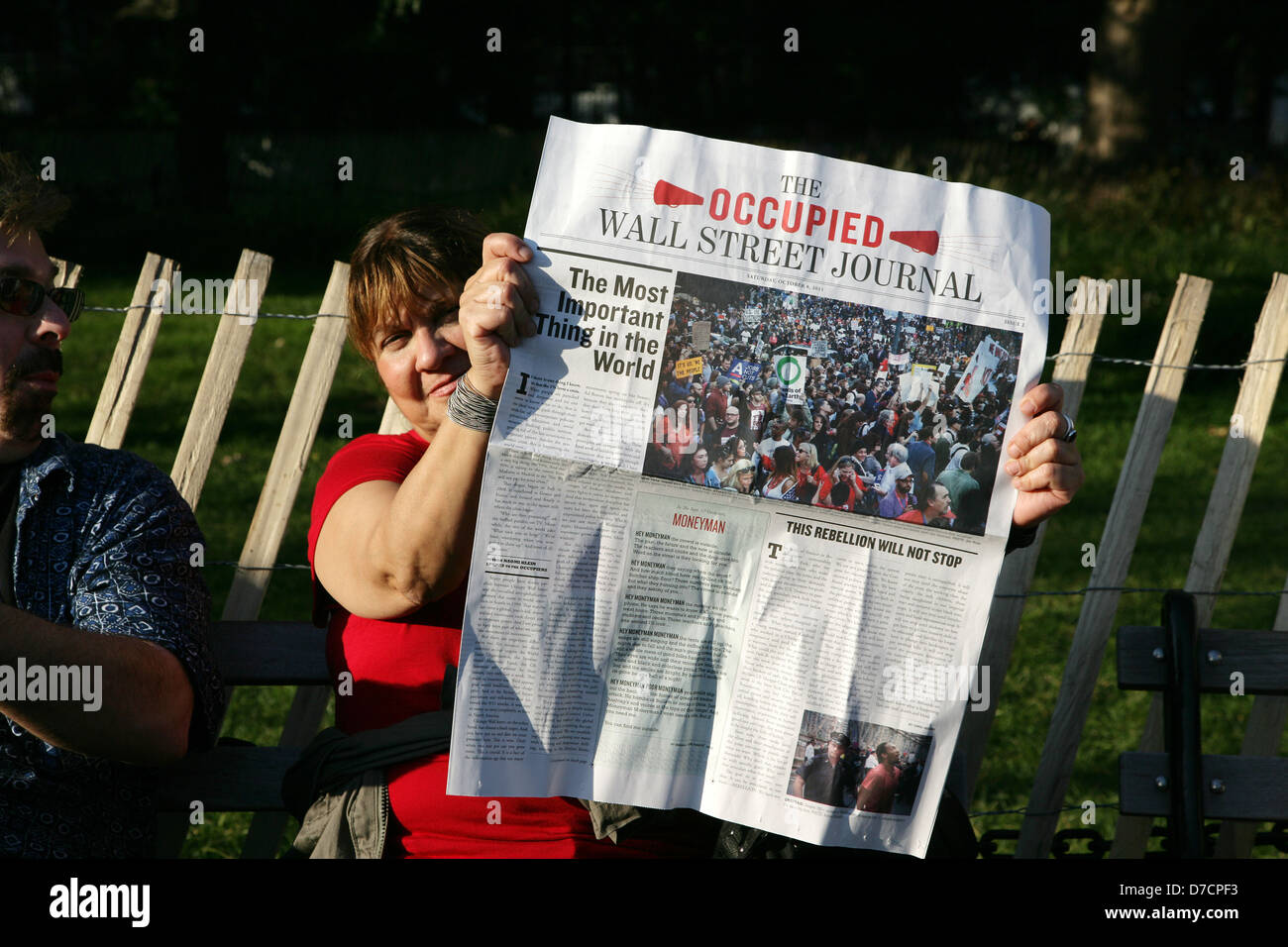 A woman holds up a copy of the 'Occupied Wall Street Journal' newspaper ...