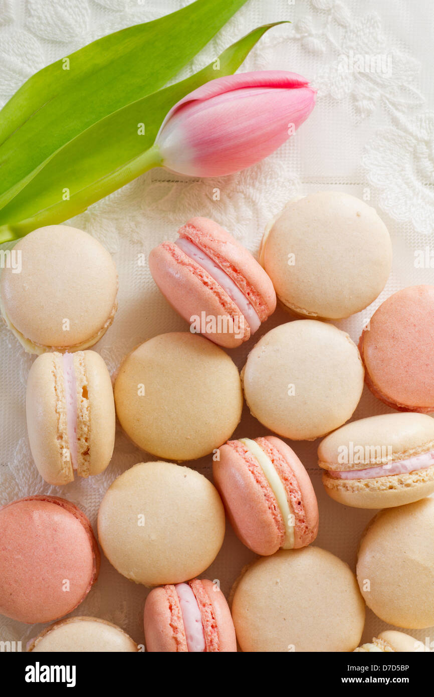 A pile of French almond macarons on white wood and lace, part of a ...