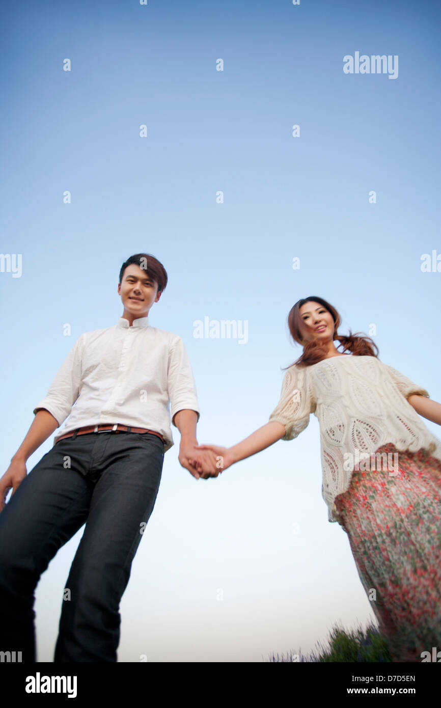 Young couple walking hand in hand Stock Photo - Alamy