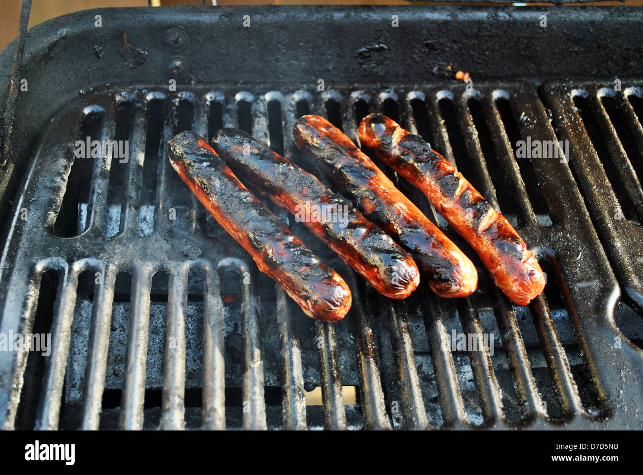 Over Cooked Hotdogs on the Grill Stock Photo - Alamy