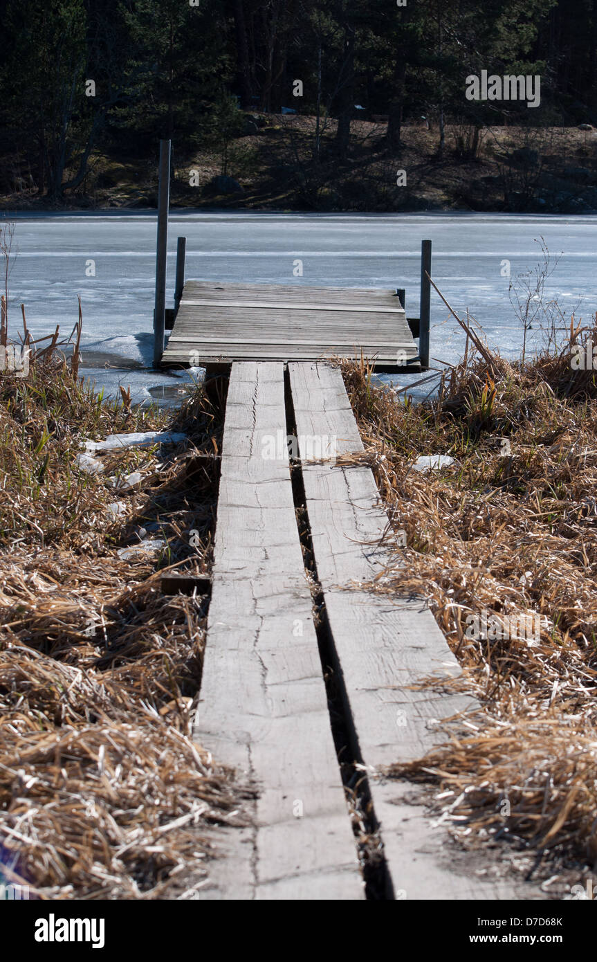 Small wood jetty and lake with ice Stock Photo - Alamy