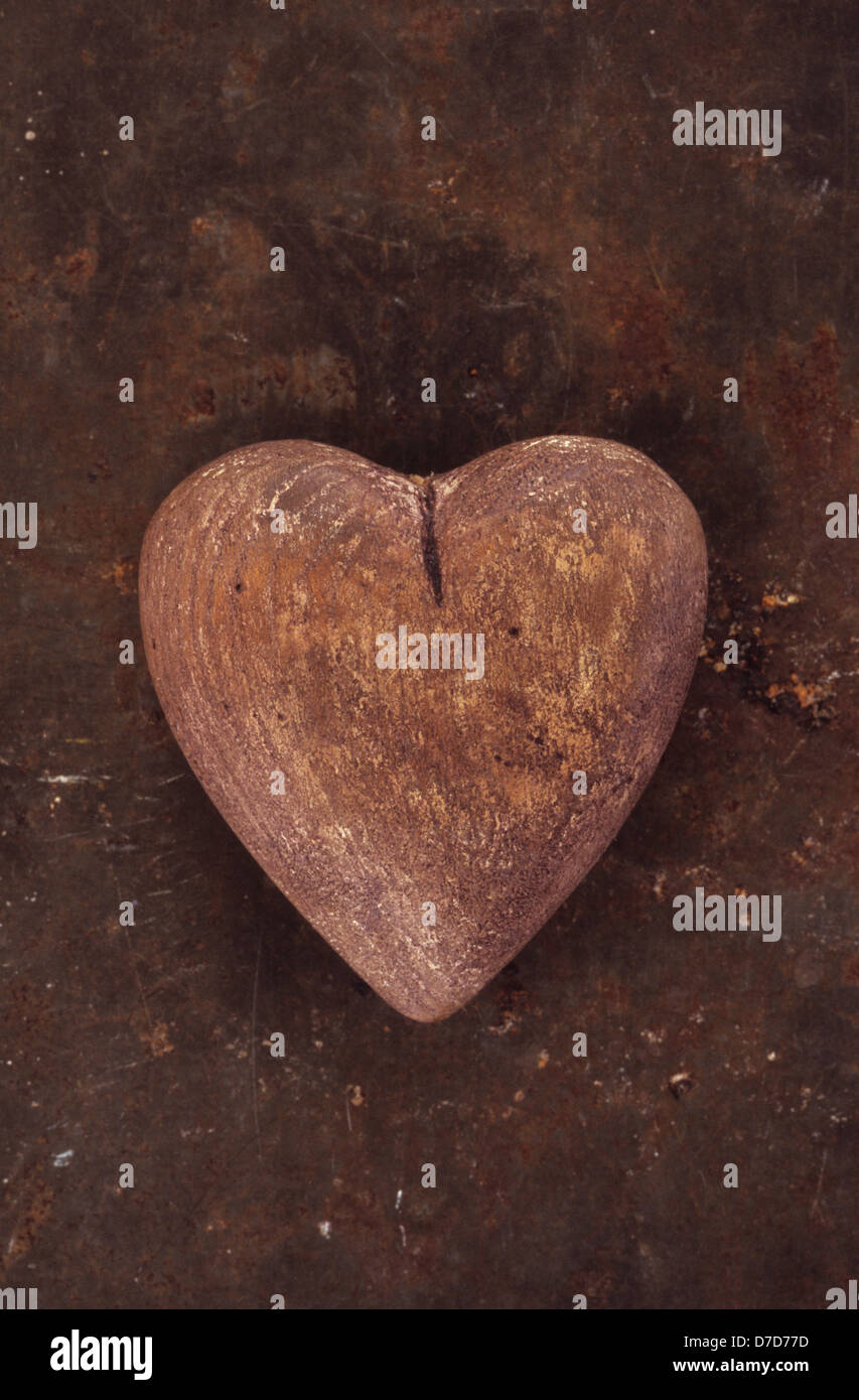 Wooden heart shape with visible woodgrain lying on rusty metal sheet ...