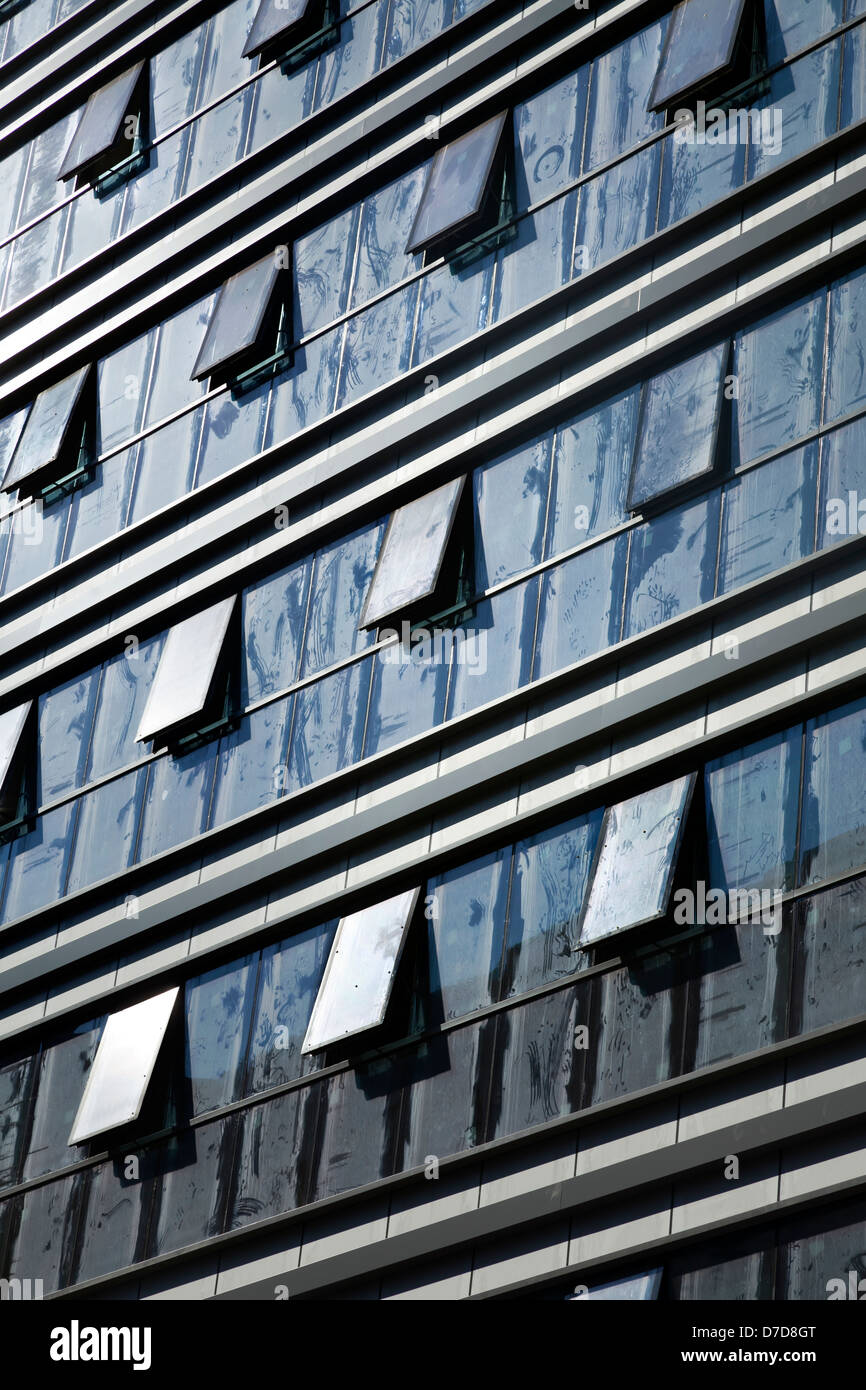 Diagonal view building's curtain wall most its windows slightly opened ...
