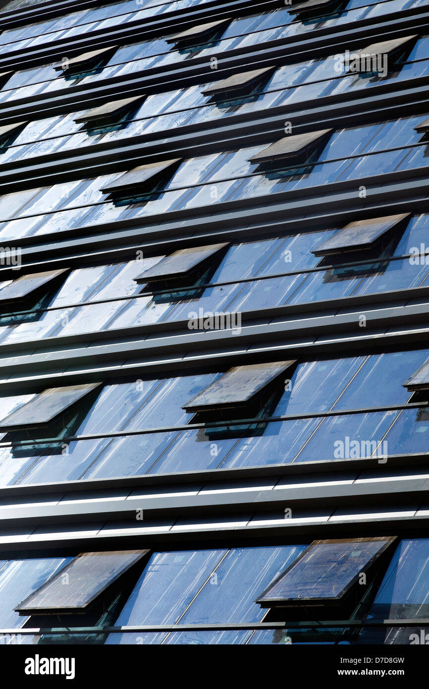 Diagonal view building's curtain wall most its windows slightly opened ...