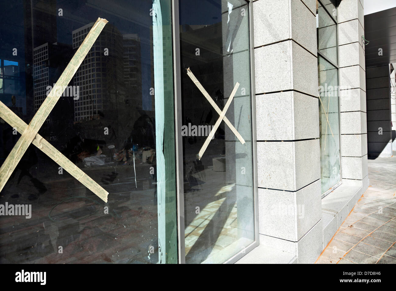 View of construction site windows, with downtown district reflecting in ...