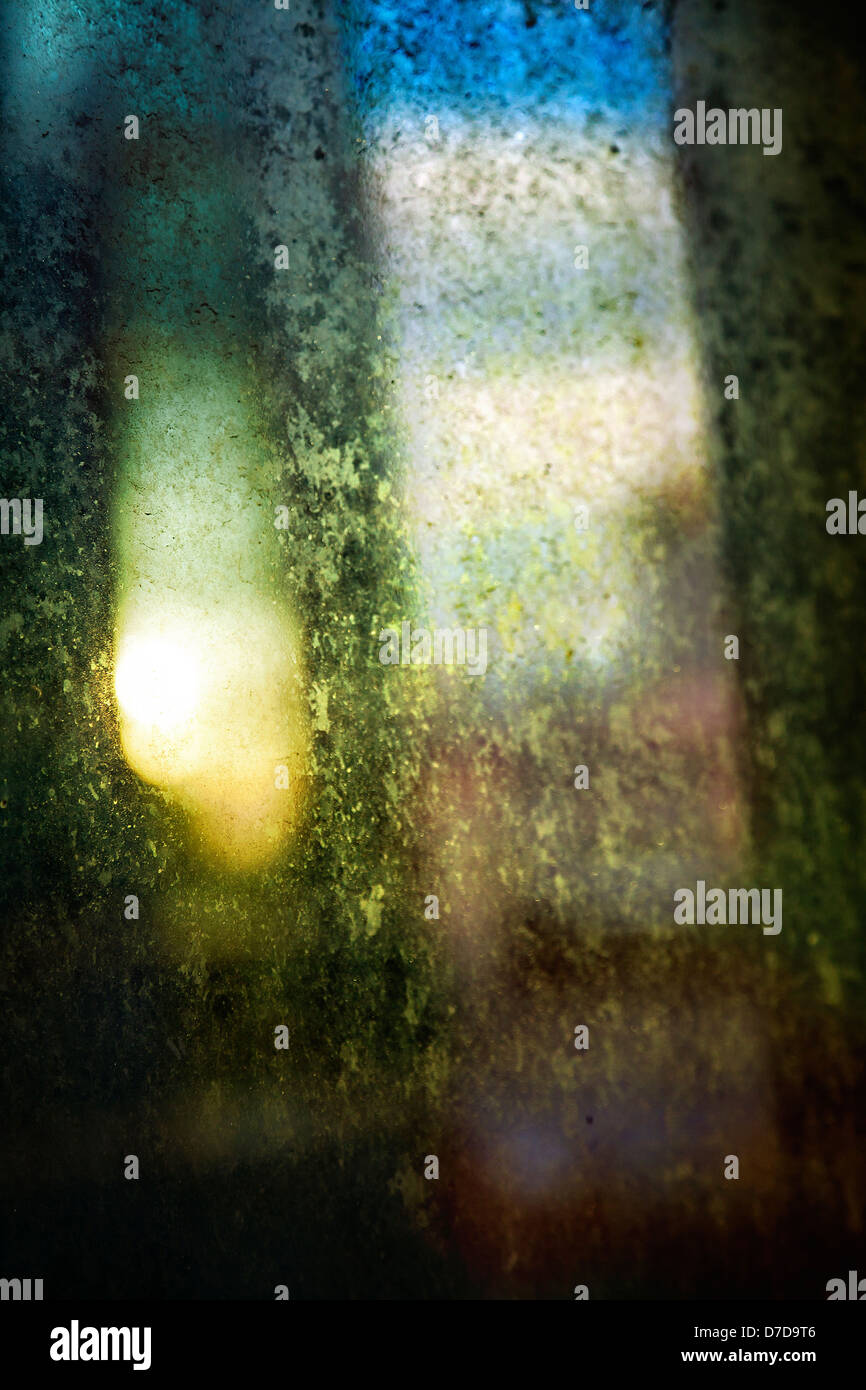 A dirty glass window back lit by ray afternoon sun inducing chiaroscuro ...