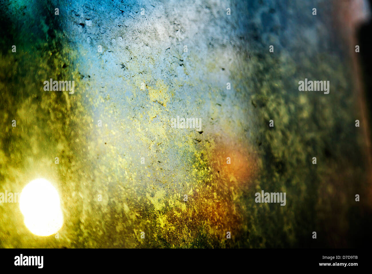 A dirty glass window back lit by ray afternoon sun inducing chiaroscuro ...