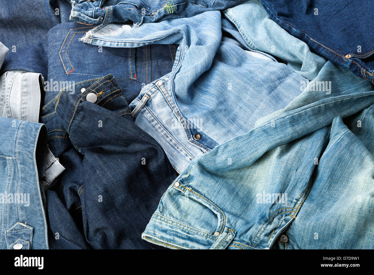 Various pairs of jeans pnats scattered in chaos Stock Photo - Alamy