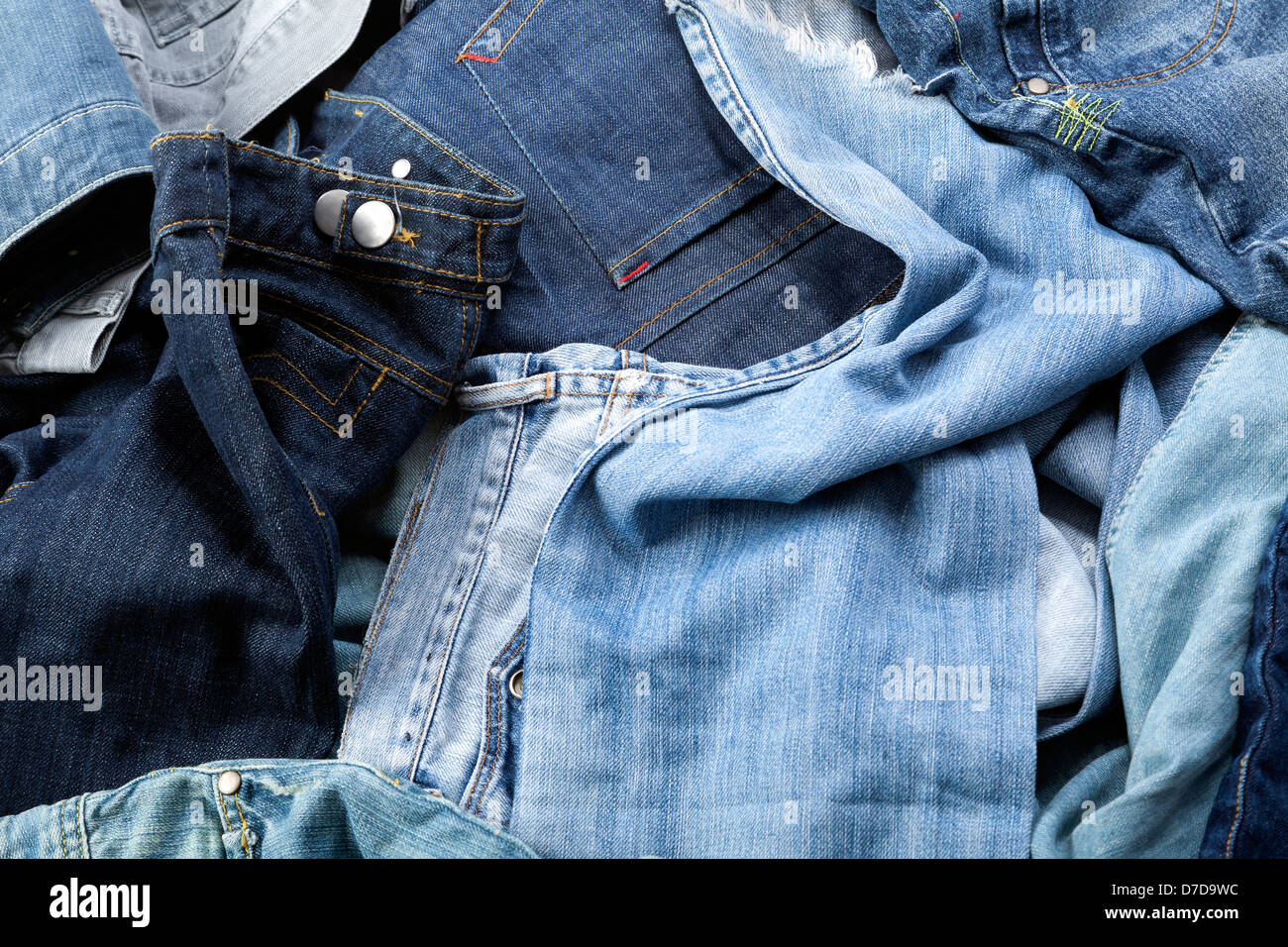 Various pairs of jeans pnats scattered in chaos Stock Photo - Alamy