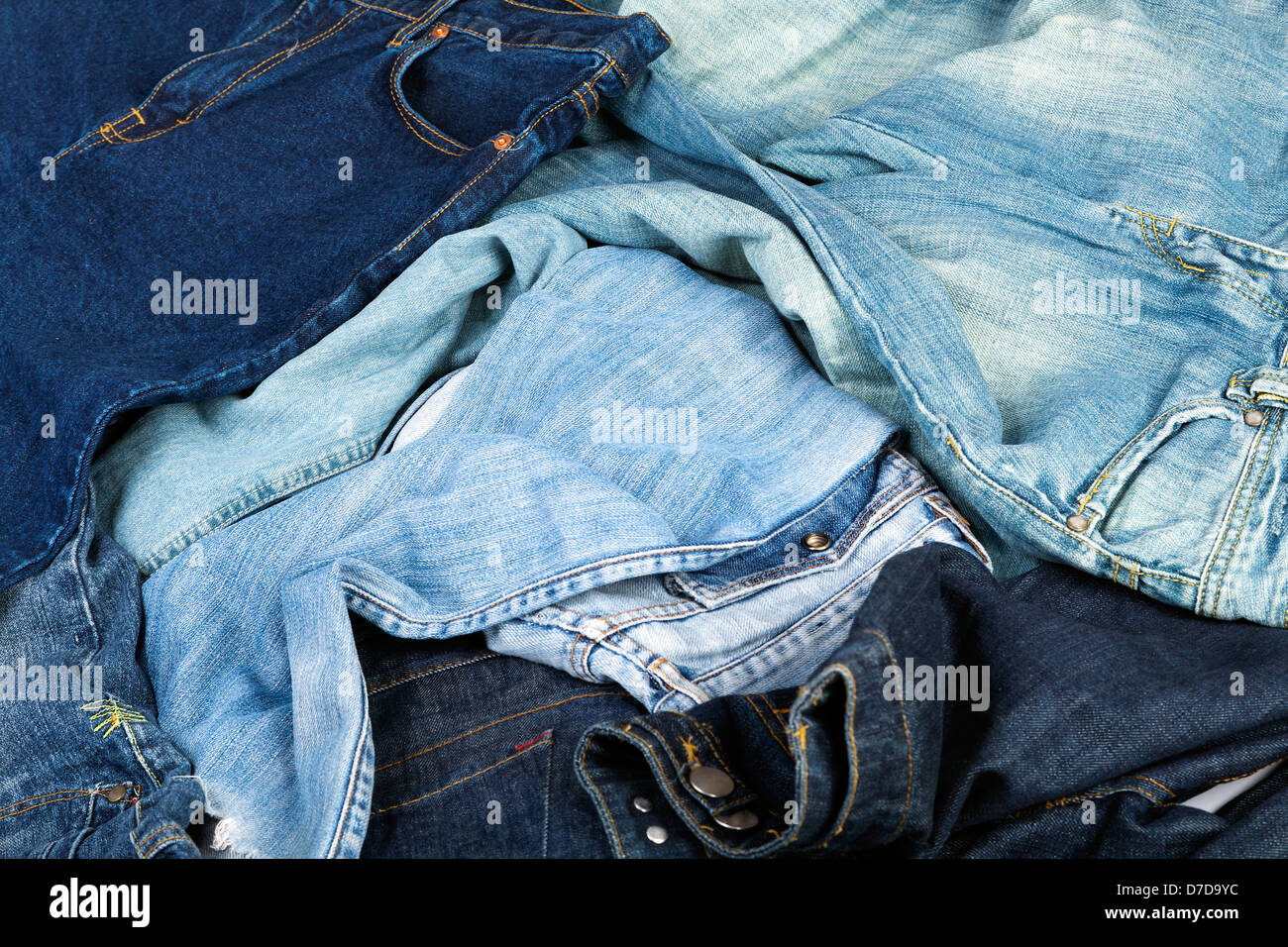 Various pairs of jeans pants scattered in chaos Stock Photo - Alamy