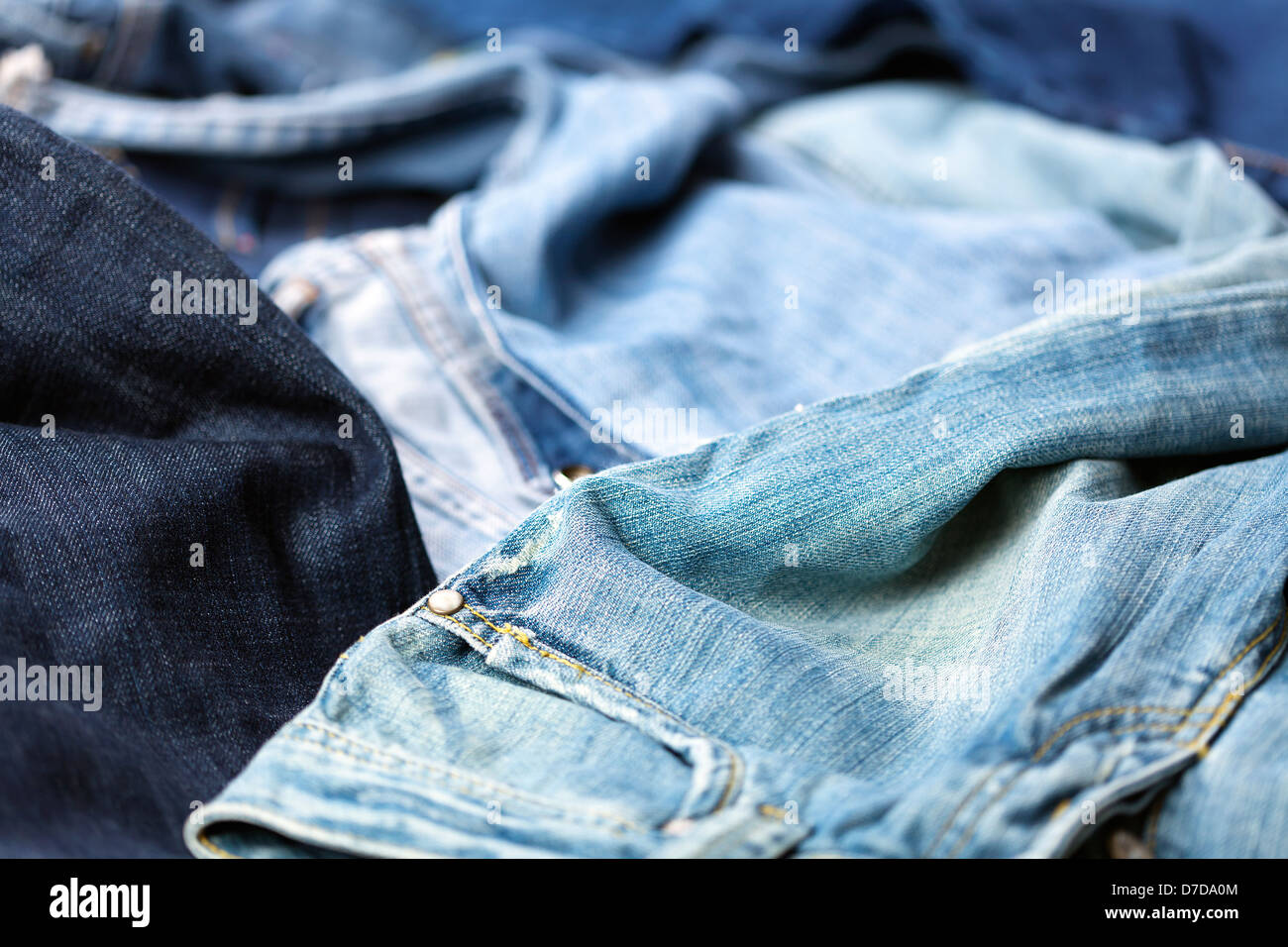 Various pairs of jeans pants scattered in chaos Stock Photo - Alamy