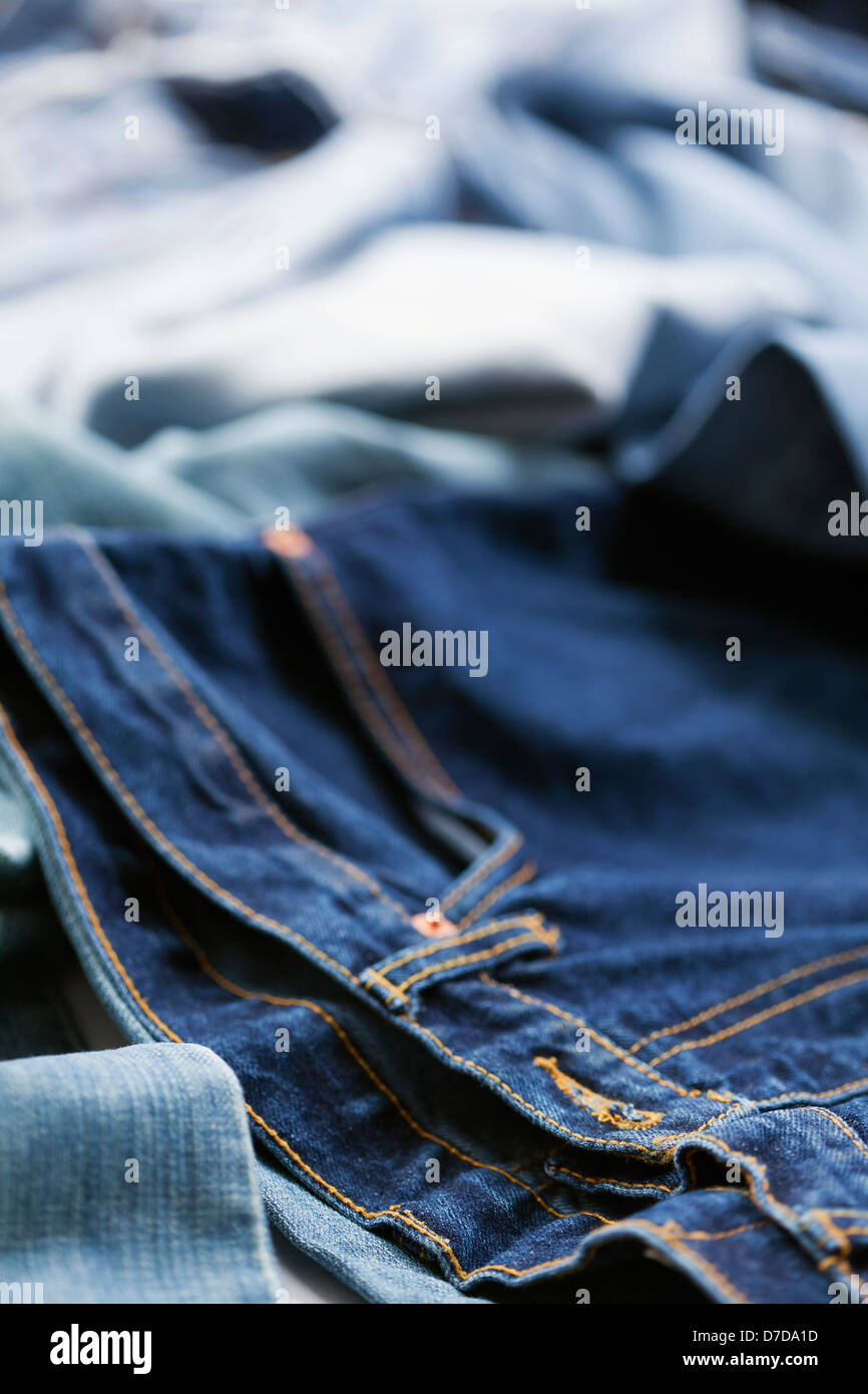 Various pairs of jeans pants scattered in chaos Stock Photo - Alamy