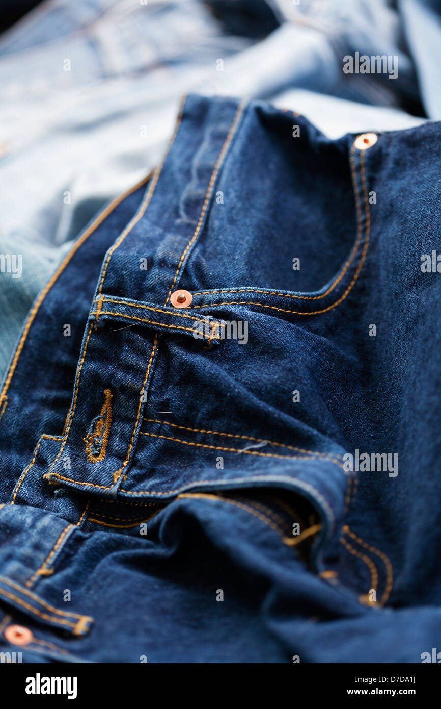 Various pairs of jeans pants scattered in chaos Stock Photo - Alamy