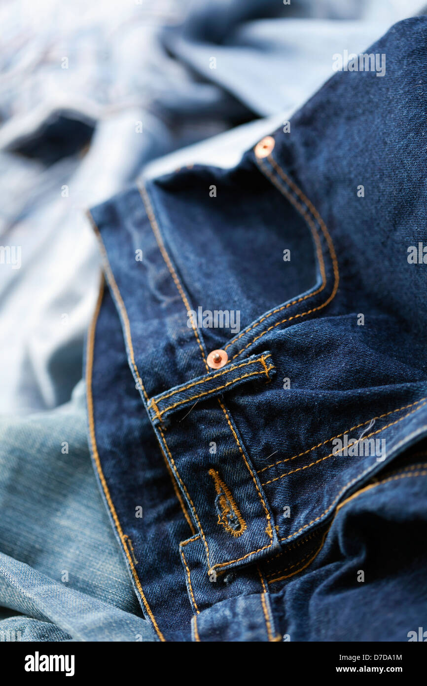 Various pairs of jeans pants scattered in chaos Stock Photo - Alamy