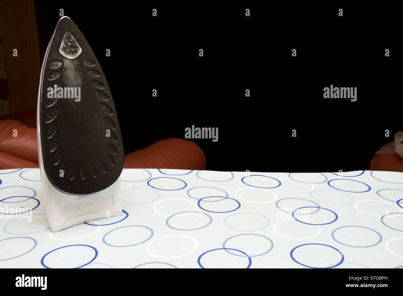 An iron standing on a ironing board Stock Photo - Alamy