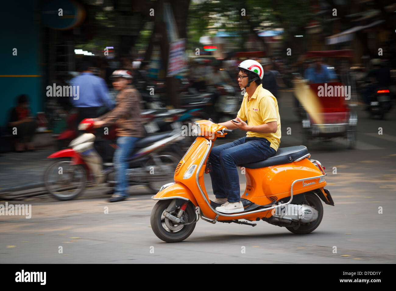A man on Vespa travelling through the Old Quarter in Hanoi, Vietnam ...