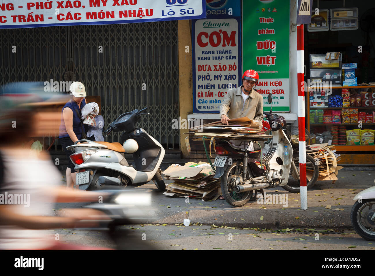 A man packing his scooter with cardboard in the Old Quarter, Hanoi ...