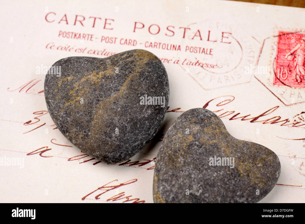 Two dark stone hearts with old French postcard Stock Photo - Alamy