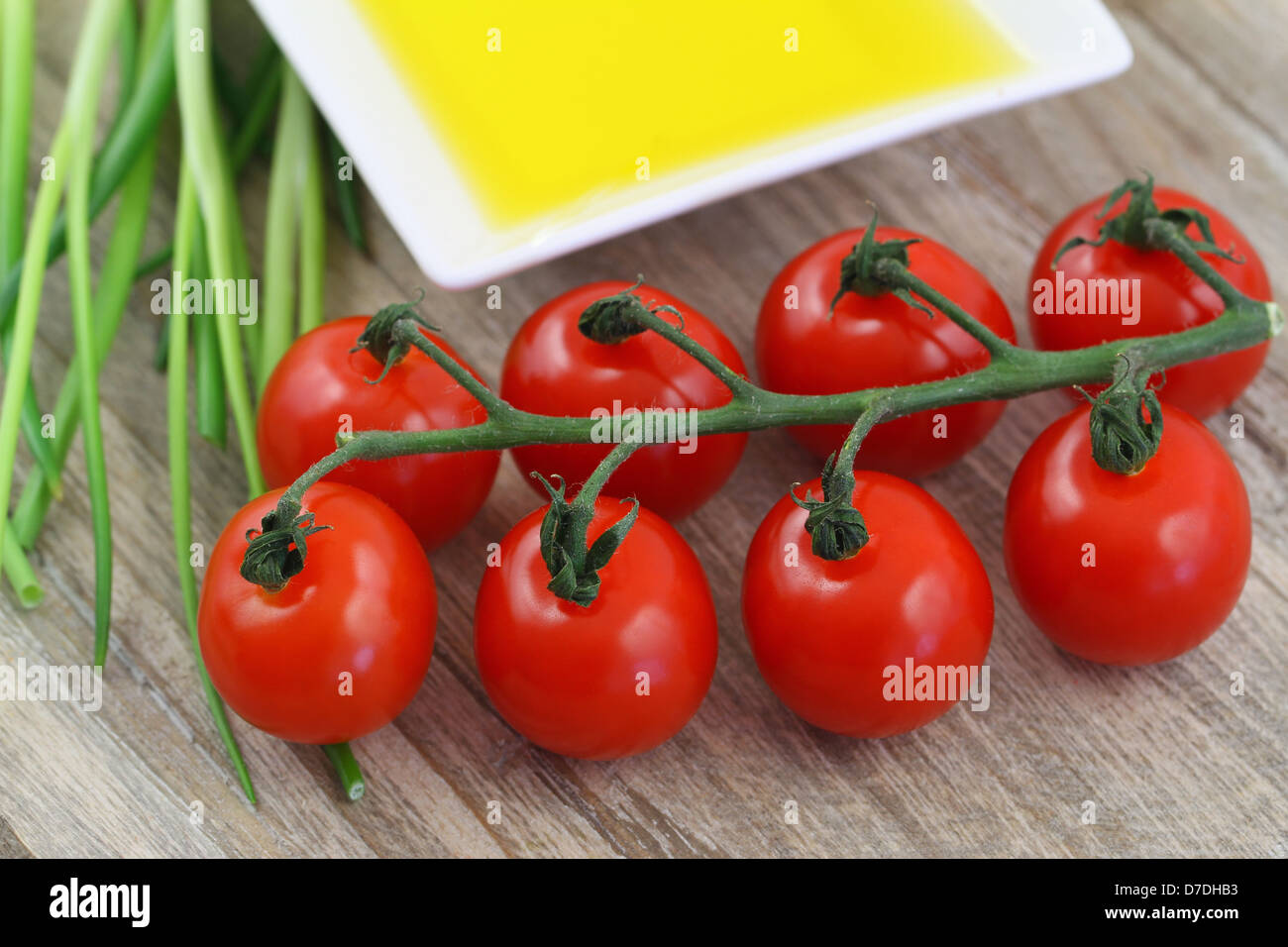 Cherry tomatoes, olive oil and chives, close up Stock Photo - Alamy