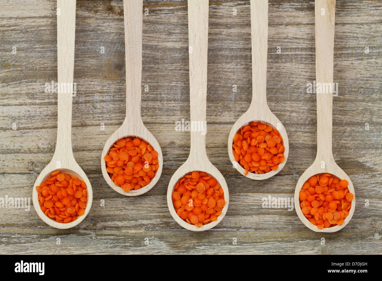 Red lentils on wooden spoons Stock Photo - Alamy