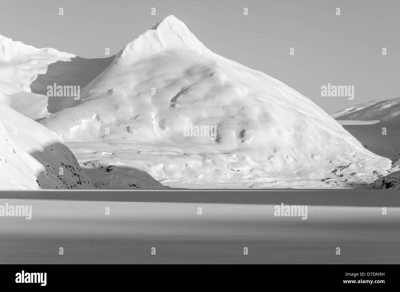 Snow covered peaks across a frozen lake in Alaska Stock Photo - Alamy