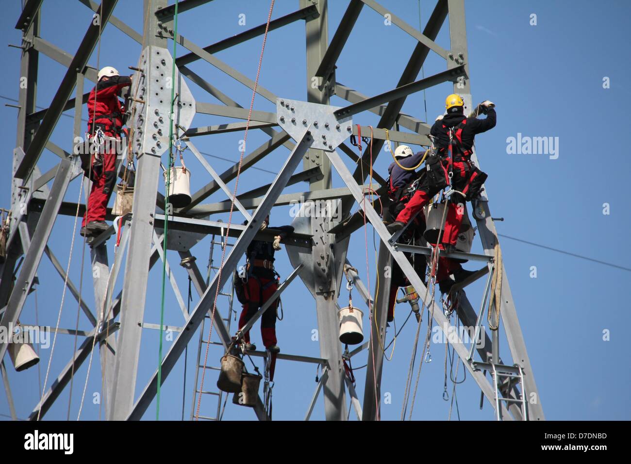 Workers prepare a lattice tower to hang power lines in Buettel, Germany ...