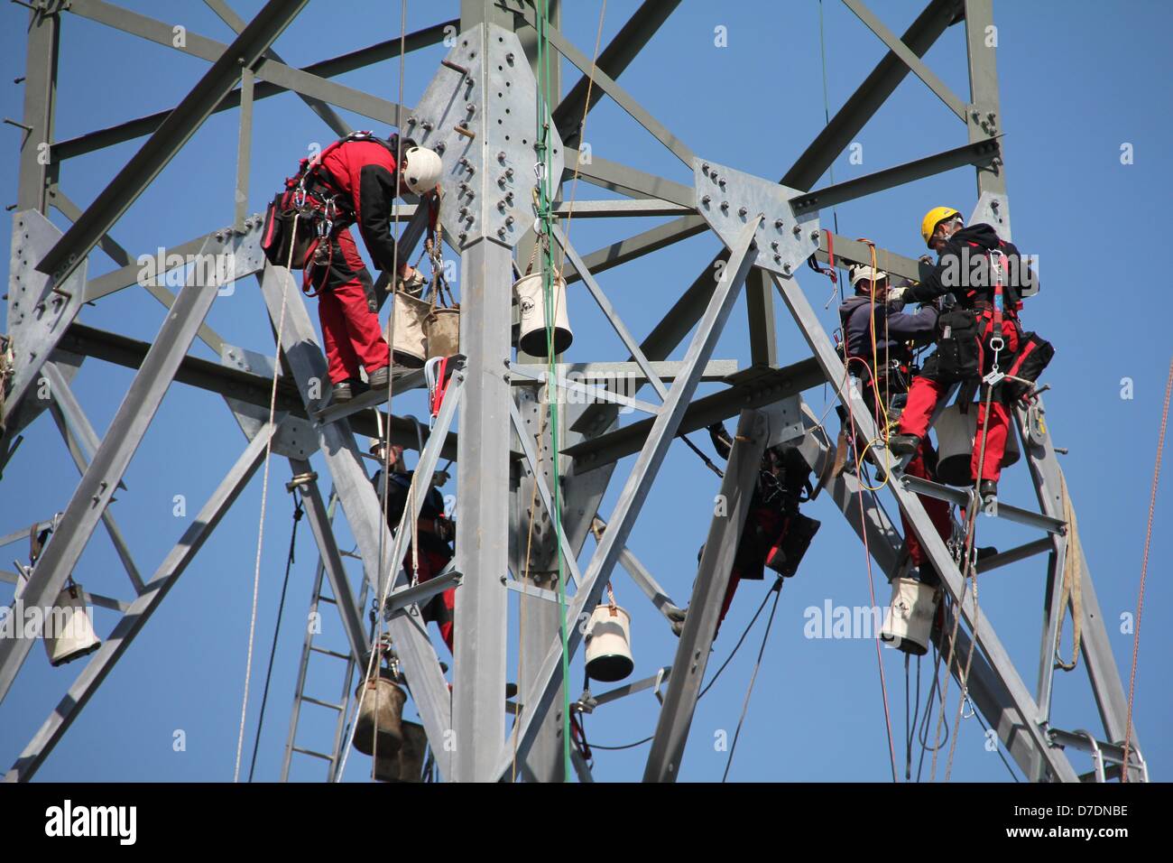 Workers prepare a lattice tower to hang power lines in Buettel, Germany ...