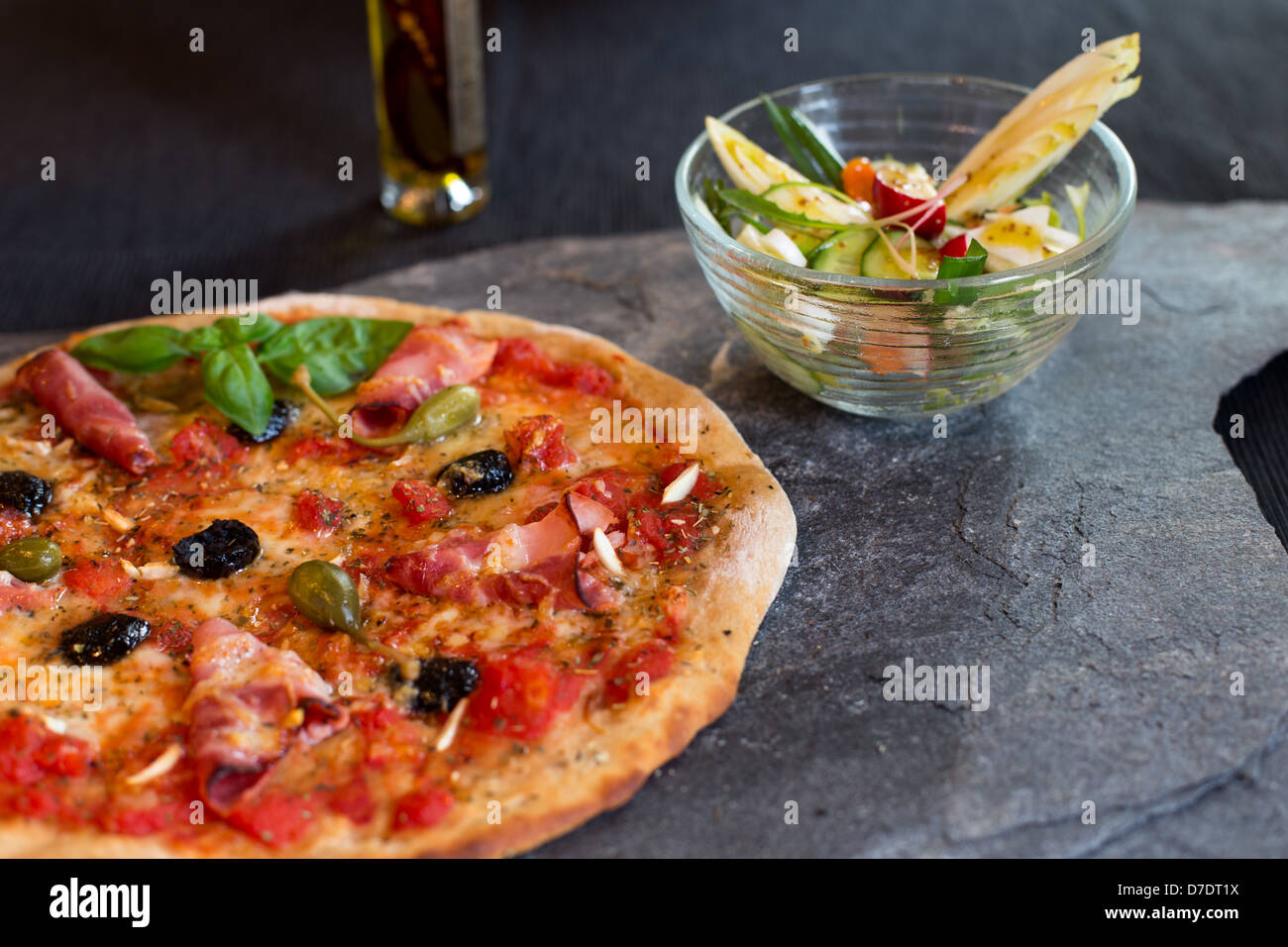 Home-made pizza with salad on stone slate Stock Photo - Alamy