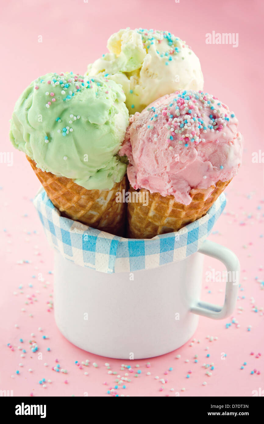 Three ice cream cones in white mug on pink vintage background with ...