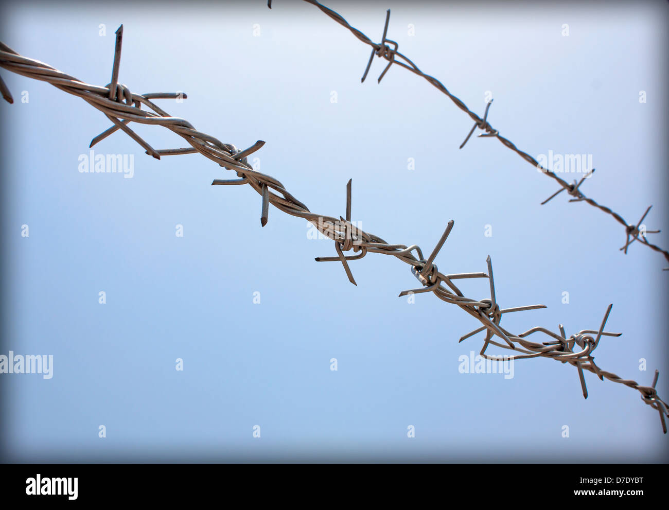 Straight fence barb wire on sky background Stock Photo - Alamy