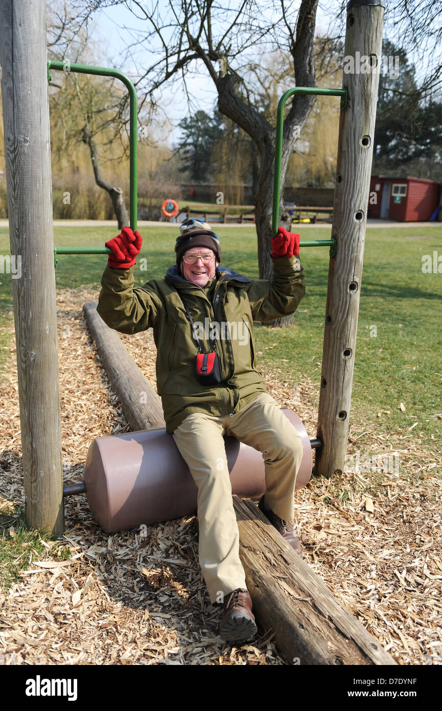 Retired grandfather playing on a revolving playground game at Newby ...