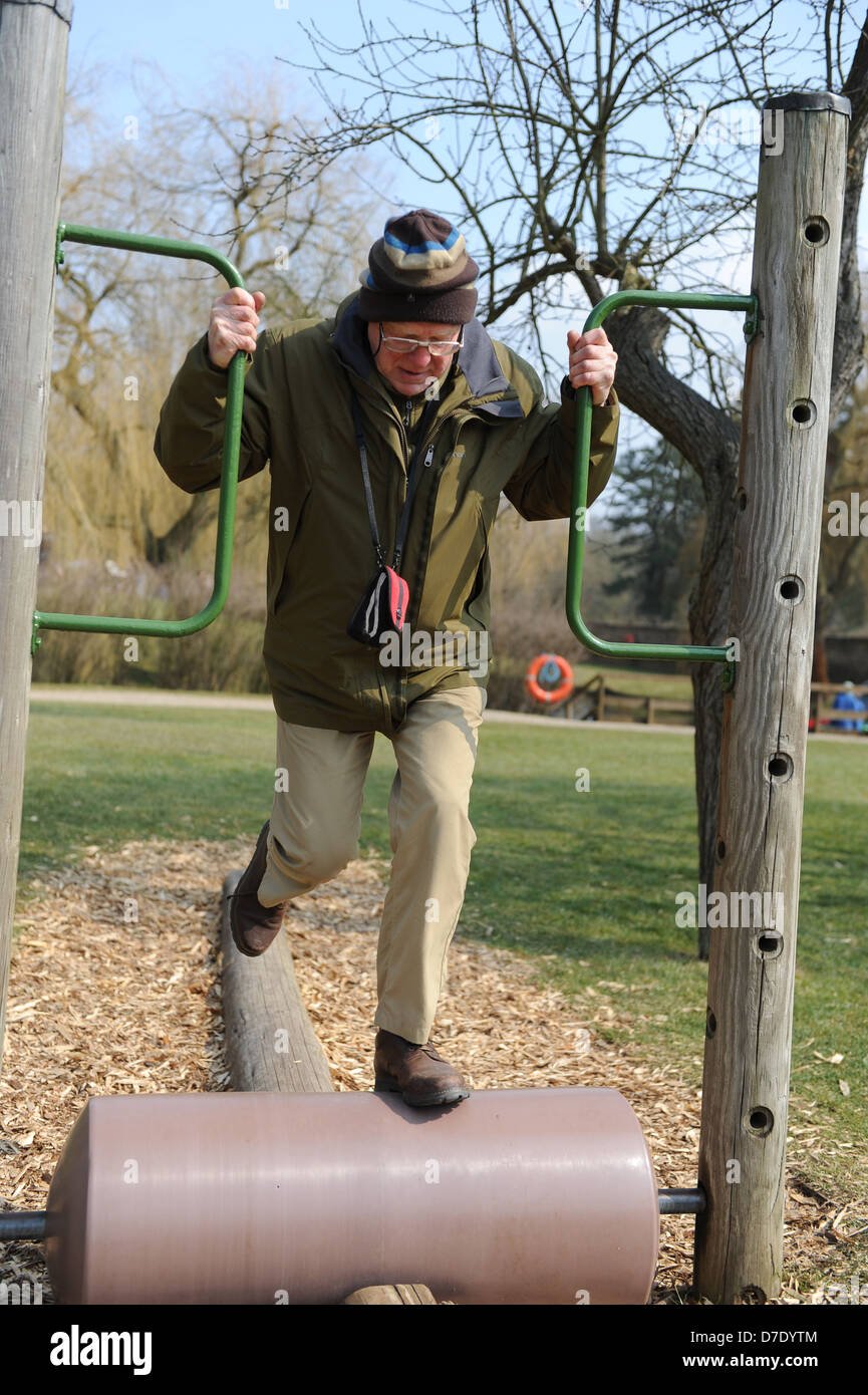 Retired grandfather playing on a revolving playground game at Newby ...