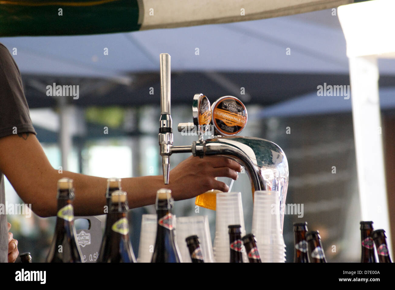 A barman pouring real ale from beer taps from Greenwich Meantime ...