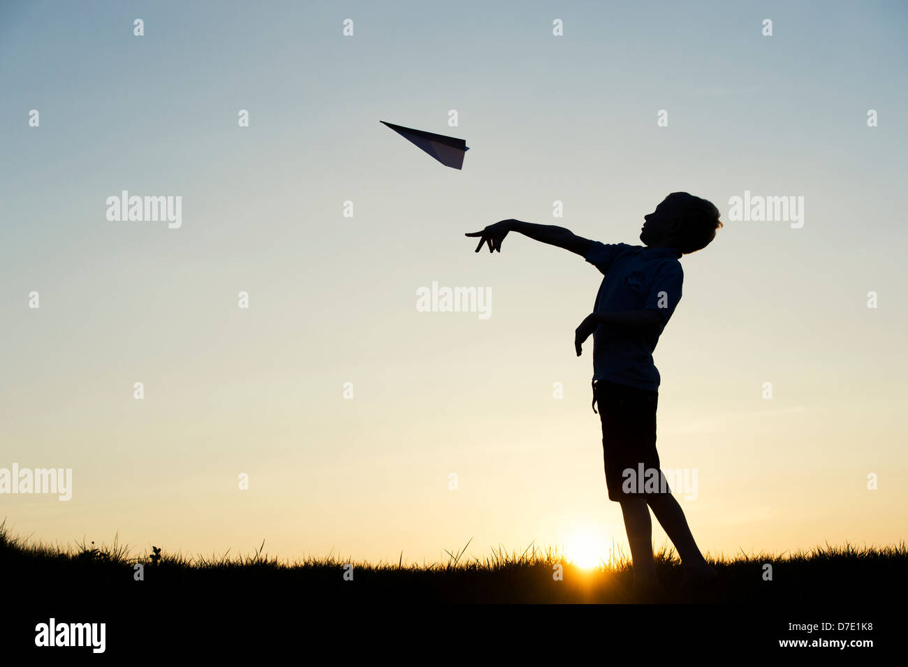 Boy throwing a paper aeroplane at sunset. Silhouette Stock Photo - Alamy