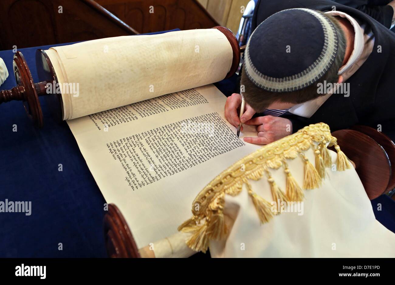 A sofer writes the last lines of the new Torah scroll in the synagogue ...